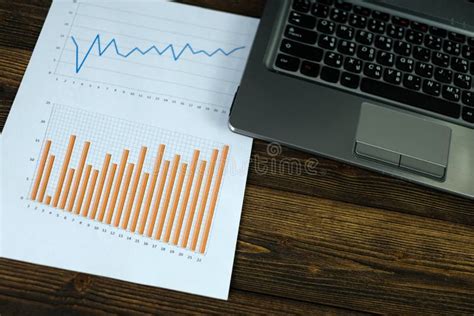 Notebook Laptop Computer And Financial Graph On White Paper On W Stock