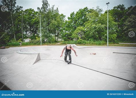 Closeup Shot Of An Inline Skater In A Skating Rink Practicing Moves With Trees In The Background