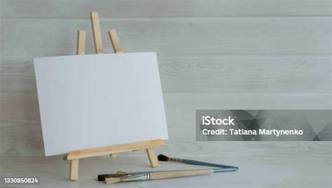 나무 벽의 배경에 흰색 빈 캔버스가있는 작은 나무 이젤 크리에이티브 워크샵 예술가의 직장 아트 스튜디오 3차원 형태에 대한 스톡 사진 및 기타 이미지 Istock