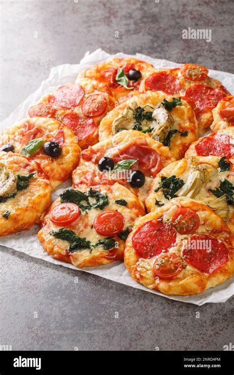 Homemade Mini Pizzas Pizzette With Meaty And Vegetarian Toppings Close Up On Parchment On The