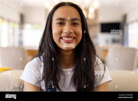 A Biracial Young Girl Wearing White T Shirt Smiling At Home Stock