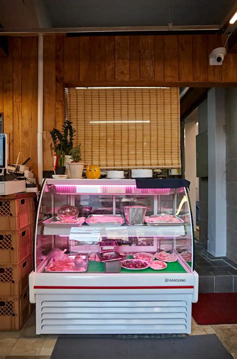 핑크빛 조명으로 시선을 사로잡는 고깃집의 쇼케이스 사진