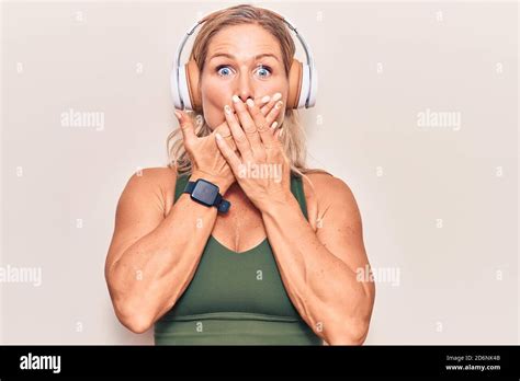Middle Age Caucasian Blonde Woman Listening To Music Using Headphones