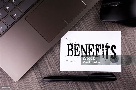 혜택을 보여주는 글을 참고 나무 배경 노트북 마우스 펜에 스티커 메모 용지에 작성 하는 회사의 고위 직원에 대 한 수당 인상 비즈니스 사진 전시 개발에 대한 스톡 사진 및