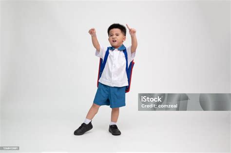 흰색 배경에 고립 된 배낭과 학생 유니폼을 입은 아시아 의 어린 소년 유치원의 첫날과 학교 로 돌아가기 개념 태국 소년 모델