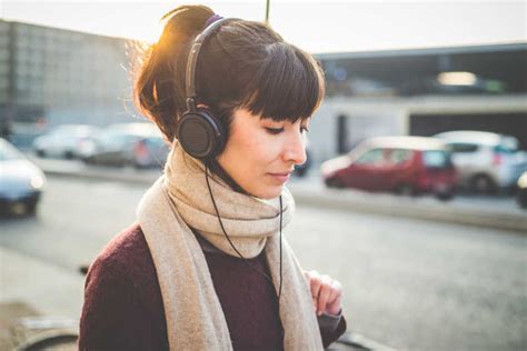 女孩戴着耳机听音乐图片 黑夜里灯光背景下漂亮的女孩戴着耳机听音乐素材 高清图片 摄影照片 寻图免费打包下载