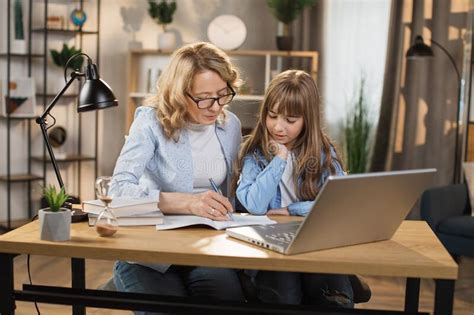 Caucasian Tutor Engaged With Schoolgirl Help Complete Tasks Sitting At
