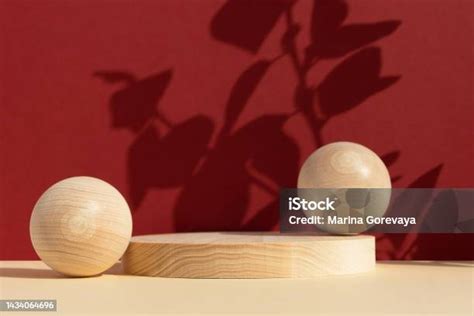 붉은 벽에 식물 잎의 그림자가있는 베이지 색 테이블에 다양한 기하학적 모양의 나무 장면 제품을 광고하고 프리젠 테이션하기위한 프리미엄 연단 쇼케이스 디스플레이 케이스 갈색에