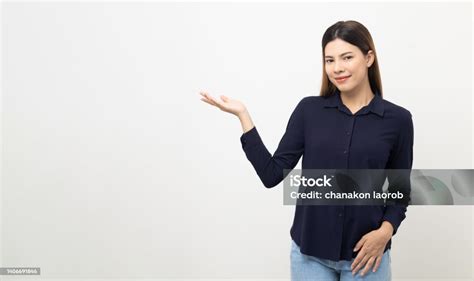 젊은 아름다운 여자는 손을 벌리고 무언가를 들고 손바닥을 뻗는다 고립 된 흰색 배경에 행복한 쾌활한 여성 텍스트를 광고하기 위한 빈 공간을 가리킵니다 가리키기에 대한 스톡