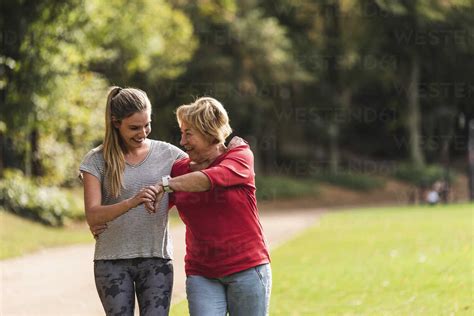 Granddaughter And Grandmother Having Fun Jogging Together In The Park