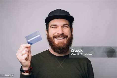 파란색 신용 카드 또는 직불 카드를 보여주는 수염이 있는 남자의 초상화를 닫습니다 신용 카드에 대한 스톡 사진 및 기타 이미지 신용 카드 쥠 남자 Istock