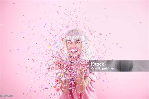 은색 머리를 가진 재미 있는 소녀는 분홍색 배경에 미소와 감정을 제공 합니다 색종이와 젊은 여자 또는 십 대 소녀 색종이 조각에