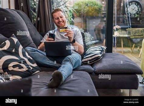 Cheerful Adult Man Looking At His Credit Card Number And Password