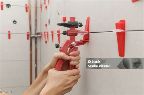 화장실 벽을 타일링하는 여자 평평한 벽 플라스틱 타일 레벨링 시스템 욕실에 타일을 설치하는 과정 Diy 주택 개량 Diy에 대한