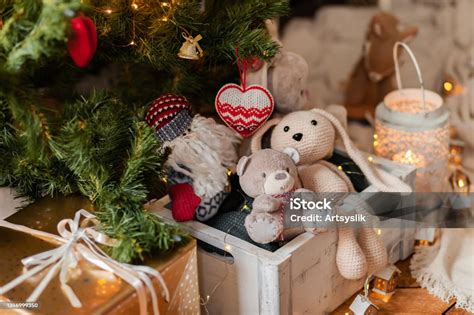 크리스마스 장식 소박한 스타일 귀여운 봉제 인형과 큰 나무 케이스 토끼 토끼와 테디 베어 녹색 장식 전나무 나무 아래 많은 선물 램프와 조명이 켜져 있습니다 새해 전야 또는
