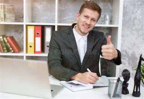 Simpático Y Guapo Gerente Con Portátil Sentado En Su Lugar De Trabajo