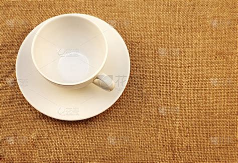 纺织品背景上的白色杯子