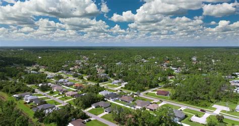 Cars Driving On Suburban Street In Florida Small Town American Rural Landscape With Private