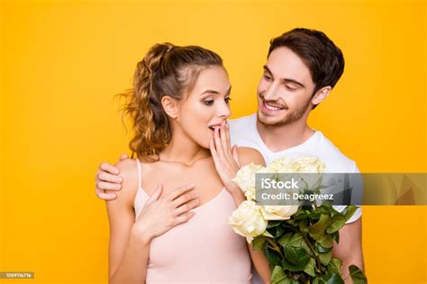 잘생긴 남자의 초상화 예기치 않은 감정 선명한 노란색 배경에 고립의 애 인에 게 흰 장미 꽃다발을 준비 합니다 기쁨 기쁨 행복