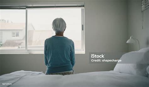 뒤로 창문 그리고 아침에 침대에 누워 향수를 생각하거나 느끼면서 깨어나는 노인 아이디어 은퇴 및 아파트에서 휴식을 취하기 위해