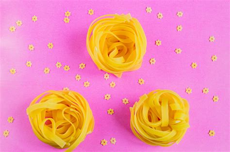 창백한 분홍색 배경에 원시 Tagliatelle 및 Stelline 파스타 흩어져 평면도 평면 위치 3가지 개체에 대한 스톡