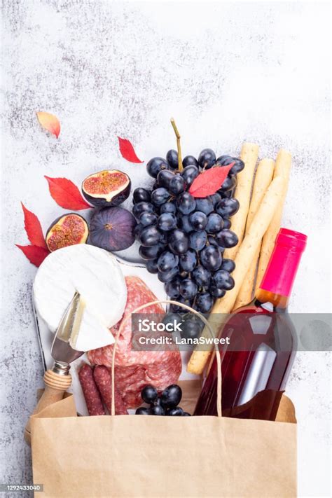 이탈리아 안티파스티 스낵과 와인이 담긴 종이 봉투에 담긴 전채 포도 무화과 치즈 카망베르 빵 막대기 고기 스네크 안티파소 미식가