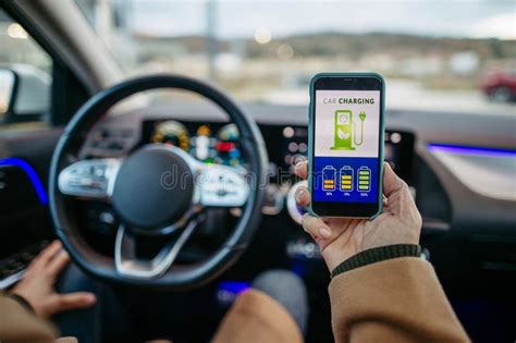 Close Up Of Man Using Electric Vehicle Charging App Checking Battery