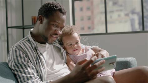 Young Black Man Watches Cartoons With Small Daughter Stock Video