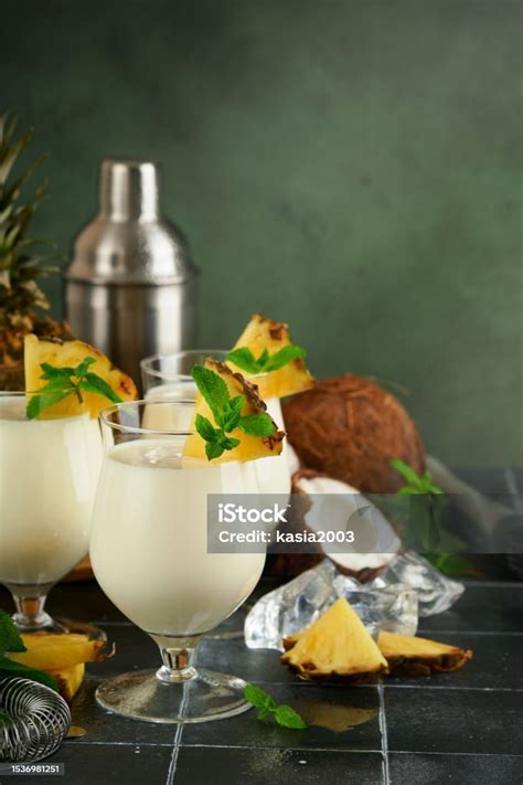 피나콜라다 럼 파인애플 주스 코코넛 크림으로 만든 전통적인 카리브해 칵테일과 열대 과일 신선한 녹색 배경에 바 도구가 있습니다 여름 열대 칵테일과 휴식 개념 각얼음에 대한