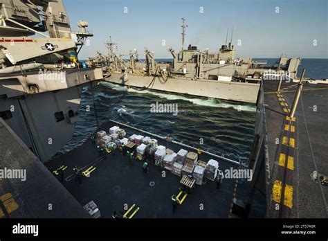 Us Navy Sailors Remove Cargo From An Aircraft Elevator During A Vertical Replenishment Aboard