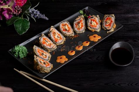Set Sushi Rolls On A Black Rectangular Plate On A Dark Background Stock