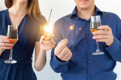 以孟加拉灯光和香槟杯庆祝圣诞节或新年夜晚会的男女近身高清图片下载 正版图片506274612 摄图网