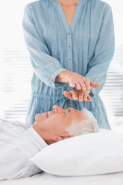 Premium Photo Therapist Performing Reiki Over Forehead Of Man