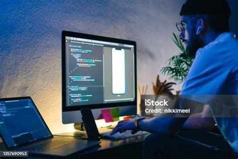 Young Man Mobile Developer Writes Program Code On A Computer Programmer Work In Home Office