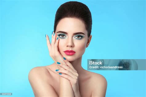 근접 촬영 초상화 아름다움 여자 메이크업입니다 잘 손질 된 손톱입니다 아이 섀도 레드 매트 립스틱 파란색 배경 위에 절연과