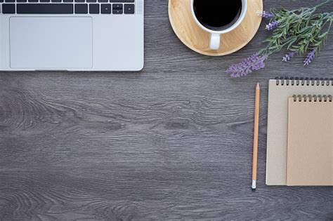 키보드와 커피 컵이있는 어두운 나무 사무실 책상 테이블 위의 상단 보기 장비 사무용품이있는 노트북 비즈니스 및 금융 개념 작업장 플랫 은 빈 복사 공간이 있습니다 개념에