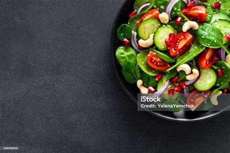 신선한 오이 토마토 양파 석류 참 깨와 검은 배경에 캐슈 너트와 시금치 샐러드 건강 한 채식 음식입니다 상위 뷰 건강한 생활방식에 대한 스톡 사진 및 기타 이미지 Istock