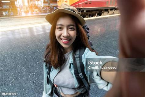 기차역에서 사진이나 셀카를 찍는 배낭을 가진 매력적인 젊은 아시아 여성 여행자 여행 라이프 스타일 개념 개성 개념에 대한 스톡