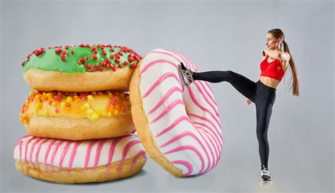 운동하는 한 소녀는 정크 푸드를 먹기를 거부합니다 피트니스 트레이너는 건강한 식단을 선택합니다 몸매가 좋은 미녀는 단 것을 거절한다 정크 푸드 음식에 대한 스톡 사진 및