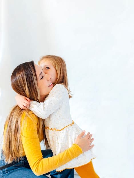 Madre Abrazando A Su Hija Contra Un Fondo Blanco Foto Premium