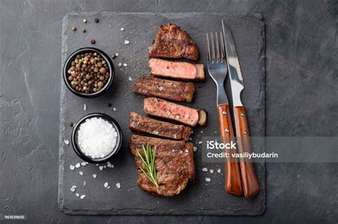 허브 마늘 돌 보드에 버터와 블랙 앵거스 스테이크 뉴욕 쇠고기 사육을 먹을 준비가 근접 촬영 어두운 돌 배경에서 저녁 식사 완성 된 요리 상위 뷰 0명에 대한 스톡 사진 및