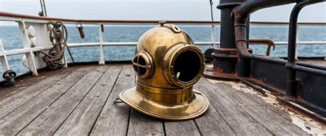 Antique Brass Diving Helmet Resting On A Weathered Ships Deck By The