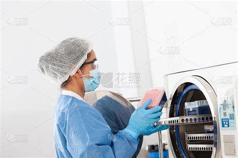 年轻的女科学家在高压釜中灭菌实验室材料