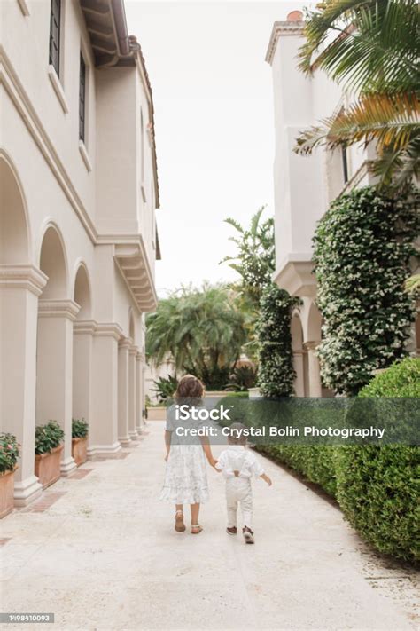 2023년 5월 플로리다주 팜비치에서 세이지 그린과 화이트 스프링웨어를 입고 손을 잡고 함께 걷는 남매의 라이프스타일 솔직한 순간 밝은 갈색 머리를 가진 쿠바계 미국인 4세