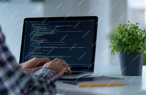 Professional Young Programmer Focused On Writing Code On Laptop In A Modern Office Environment