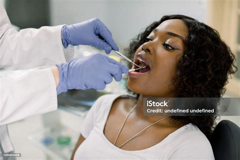 치과 및 의료 개념 치과 진료소에서 치아 검사를하는 예쁜 아프리카 계 미국인 여성 환자의 크롭 샷을 닫습니다 환자의 치아를 검사하는 파란색 장갑에 여성 치과 의사의 손 2