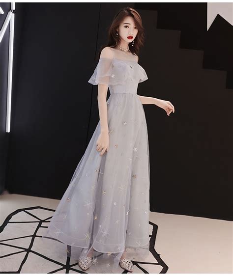 ชุดราตรียาวออกงานกลางคืน สีเทา ตัวชุดเป็นผ้าโปร่งปักรูปดาวสีเงินและสีทอง และแต่งด้วย… Vestidos