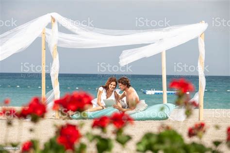 화창한 날에 해변에서 나무 정자에서 재미있고 테이블을 보는 행복한 젊은 부부 2명에 대한 스톡 사진 및 기타 이미지 2명