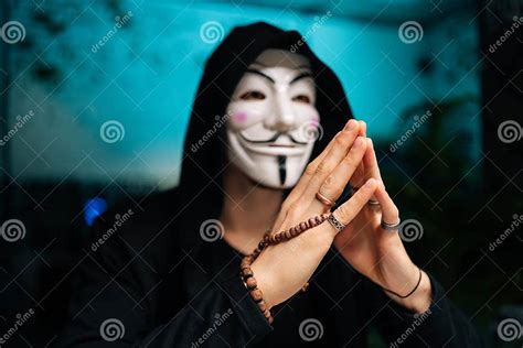 close up of dangerous hacker man wearing anonymous mask and hoodie