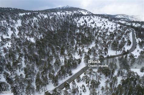 겨울에 눈 덮인 산을 가로지르는 아스팔트 고속도로의 드론 항공 사진 0명에 대한 스톡 사진 및 기타 이미지 0명 12월